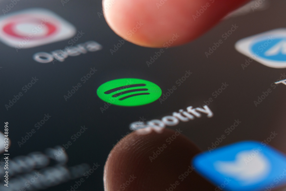 Spotify logo app on mobile screen close up with touching finger Stock ...