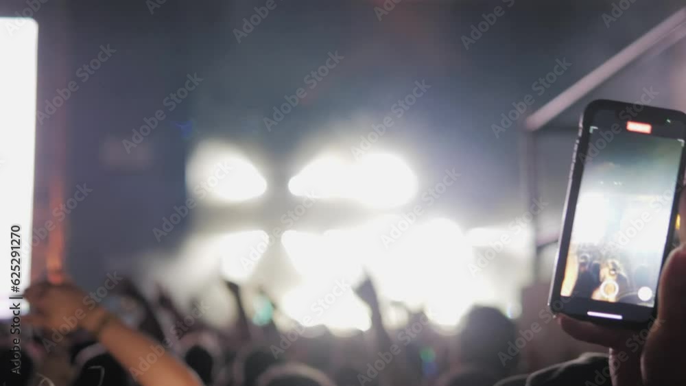 Concert people crowd applause and dancing jumping with phone camera ...