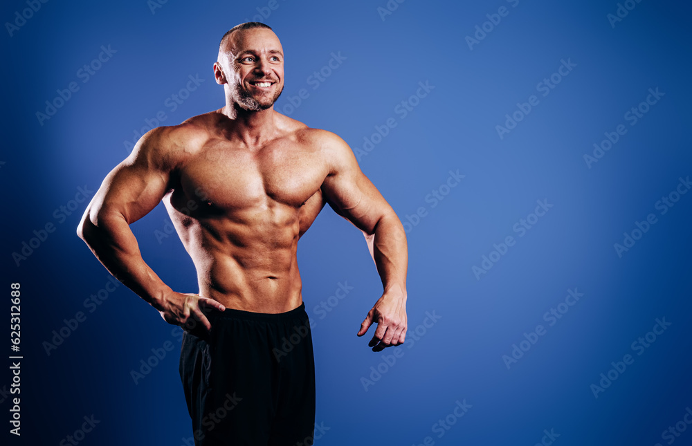 Slim muscular male model at blue background. men’s physique. Fitness ...