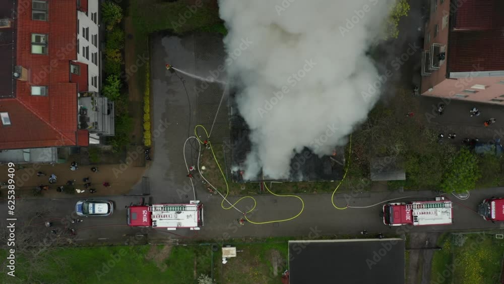 Top view of fire trucks and firefighters extinguishing a fire in a ...