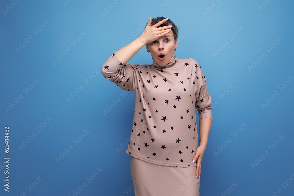 shocked young caucasian dark-haired lady in a skirt and blouse with a ...