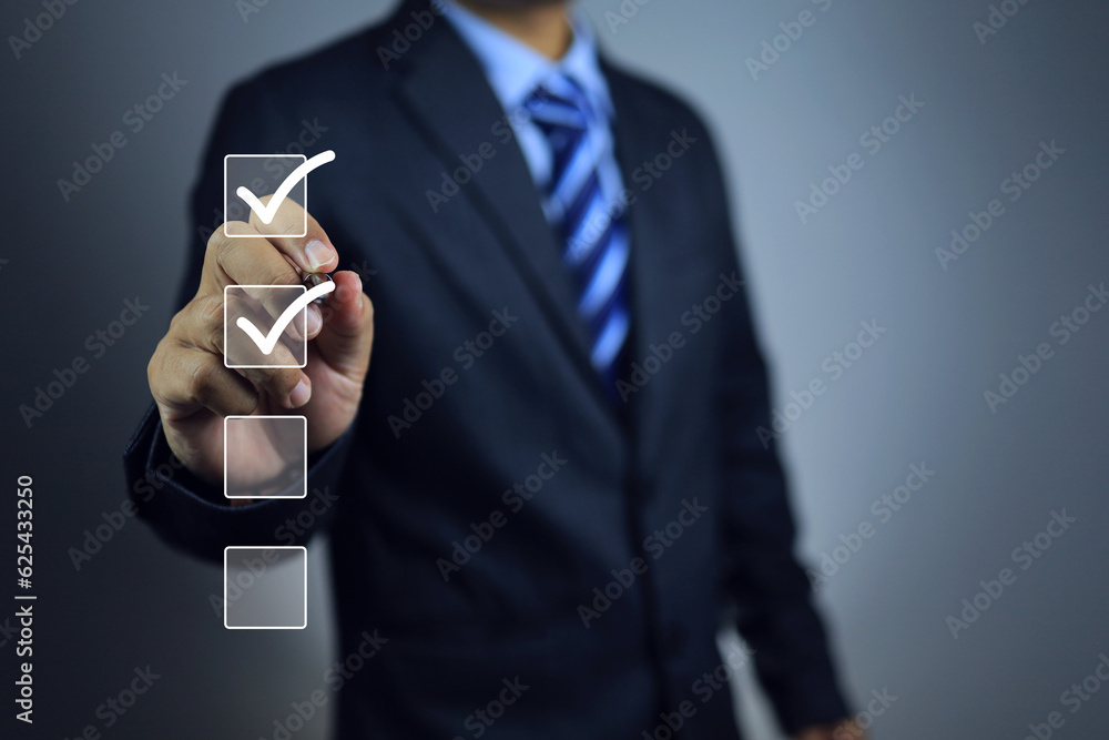 Businessman using pen to tick correct sign or check mark on checkbox to ...