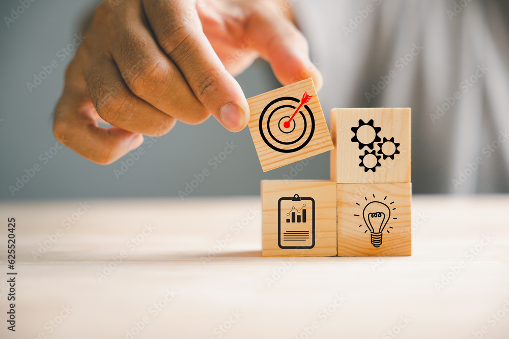 Businessman's hand skillfully arranging wood blocks to illustrate a ...