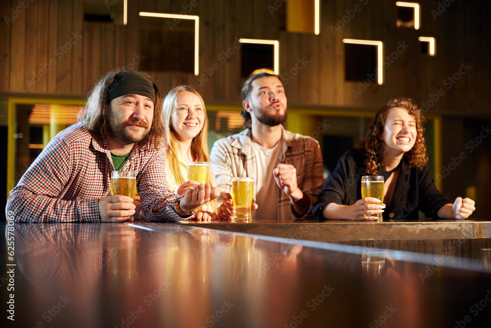 Young emotional people, friends, sport fans visiting bar, drinking beer ...