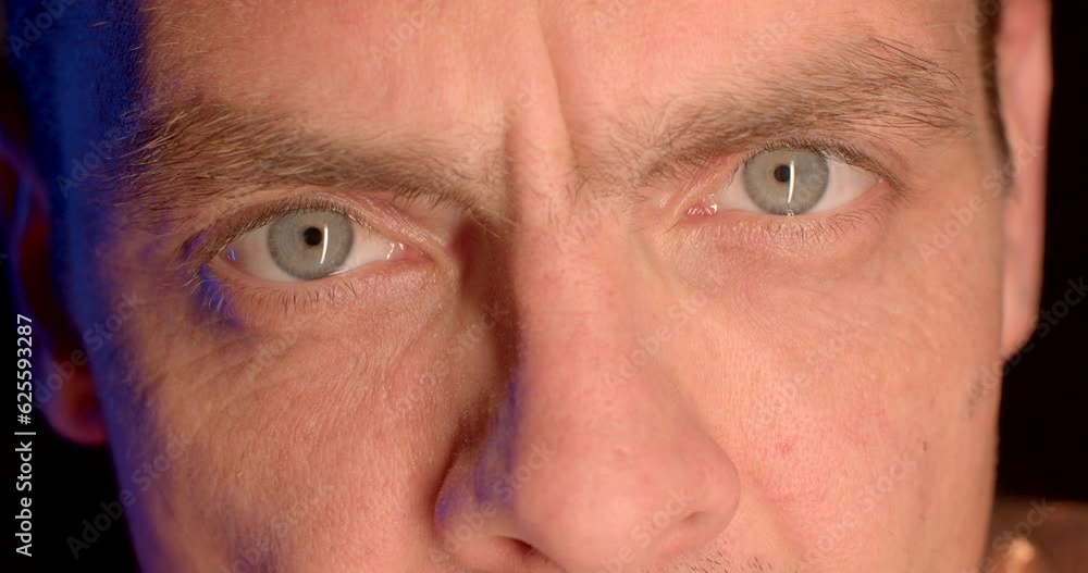 A serious look of a man, blinking eyes, a smile on his face, wrinkles ...