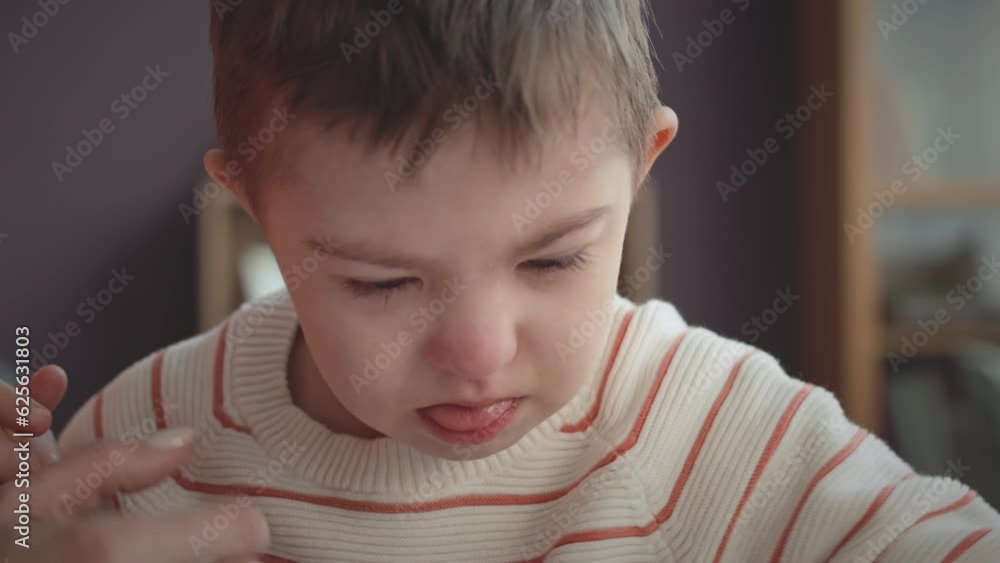 Medium closeup of 6 year old Caucasian boy with down syndrome crying at ...