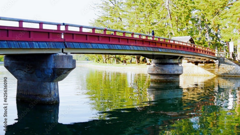 Grand pont en pierre coloré gris et rouge permettant de traverser un ...