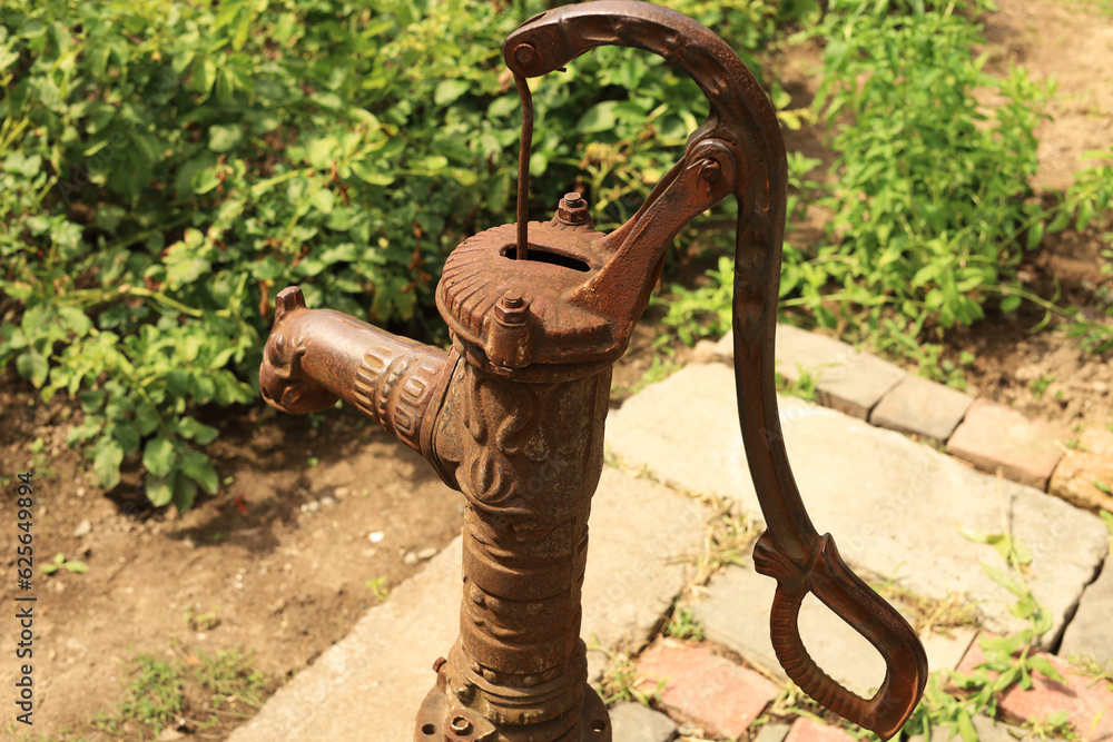 Rusted water pump. Old well and water pump. old hand pump at the well ...