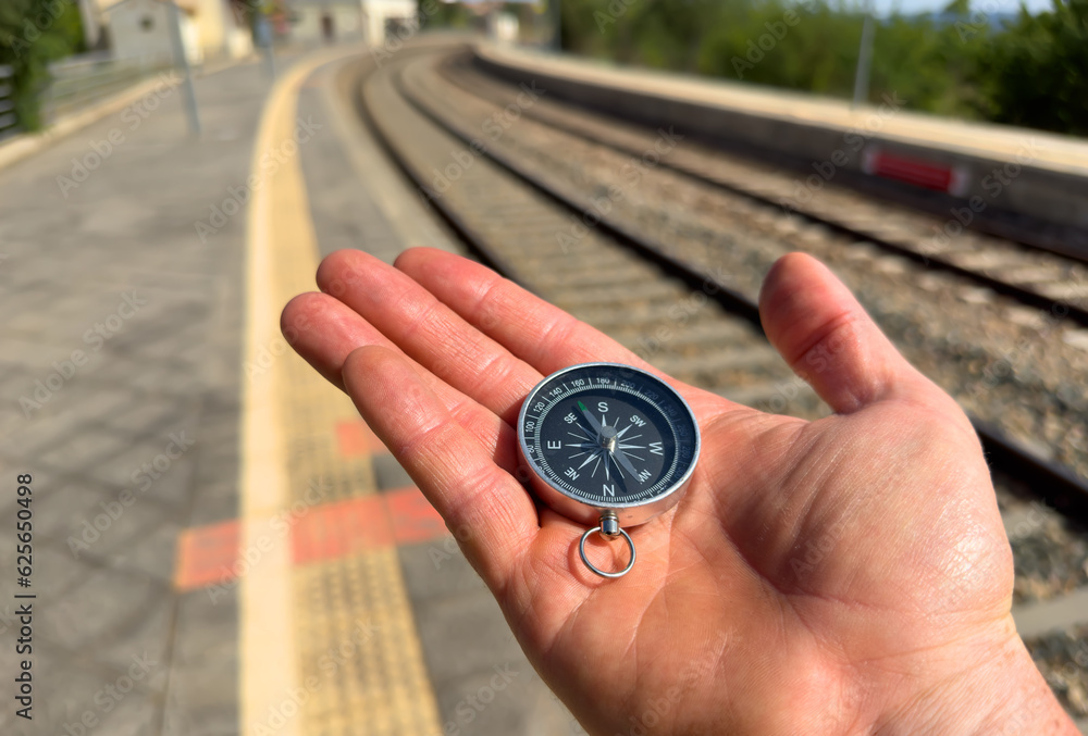 Compass in hand at railway station. Tourist compass for orientation on ...