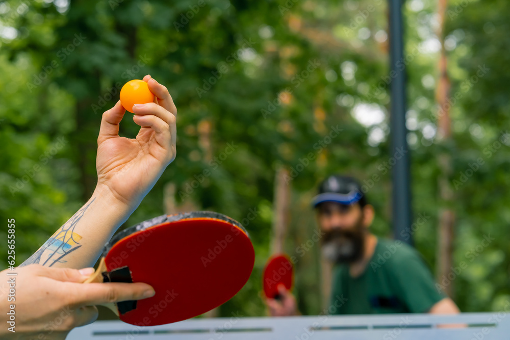 A close-up of a ping-pong ball being served against the background of ...