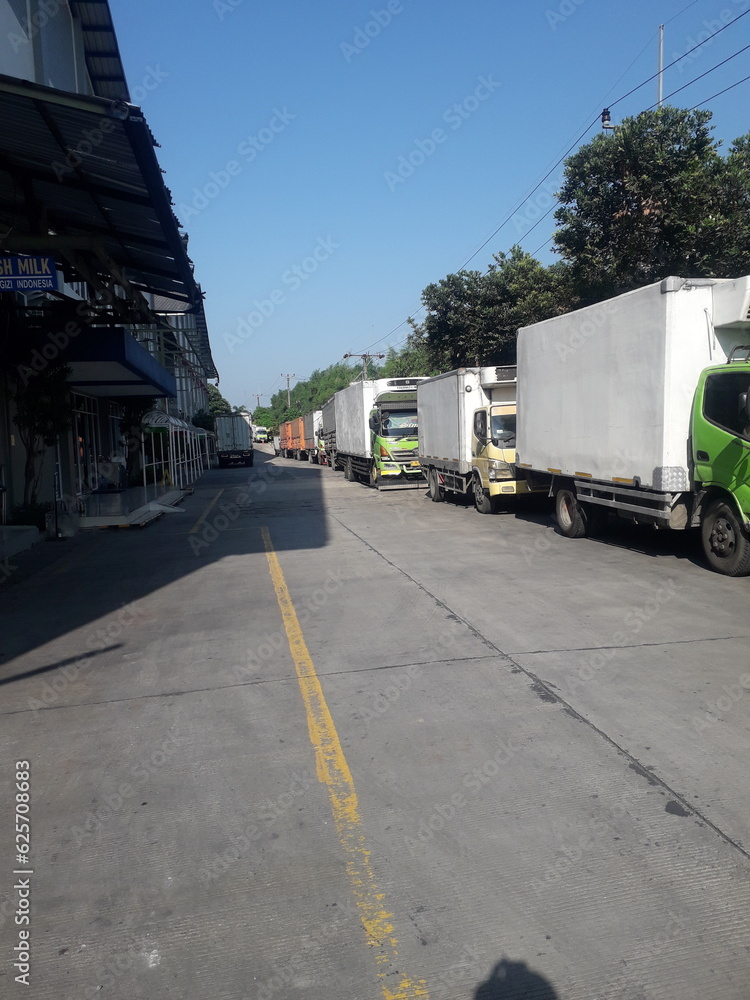 long queue of loading and unloading trucks at a warehouse, in the ...