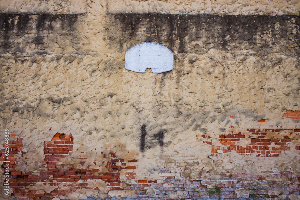 Urban concrete and brick wall with a basketball backboard missing the ...