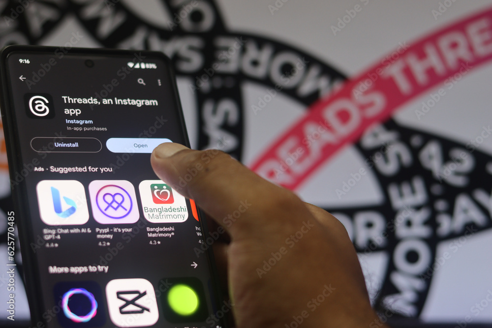 installing Threads app on a phone, The threads logo is displayed on a smartphone screen. Threads ...