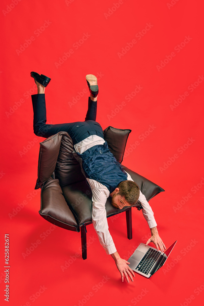 Finishing tasks. Businessman lying on armchair in weird pose, working ...