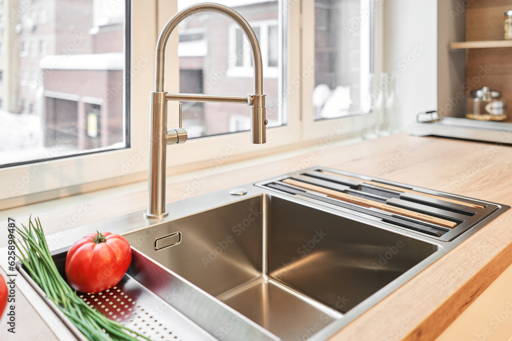 Stylish metallic crane at the kitchen. Sink faucet at the kitchen ...