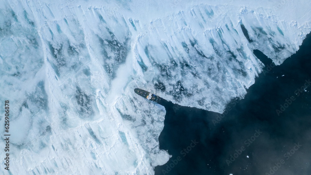 A look from above on a cruise ship making a path inside a huge ice rig ...