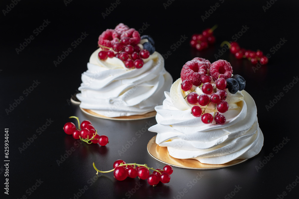 Mini Pavlova cake with raspberry, blueberry and red currant on black ...