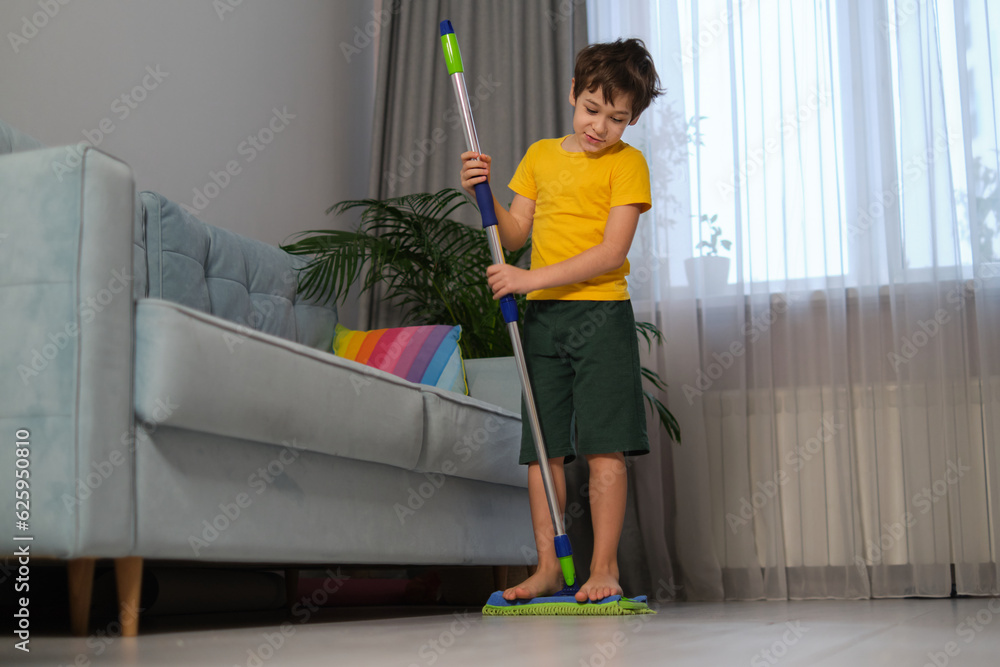 sad boy hugging a mop, parents make him clean up. boy washes the floor ...