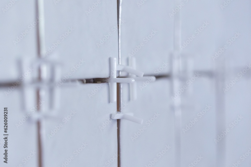 A close up portrait of plastic white joint spacers placed in the ...