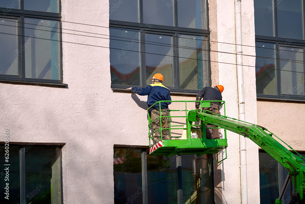 Construction workers team installing new windows on building, work at ...