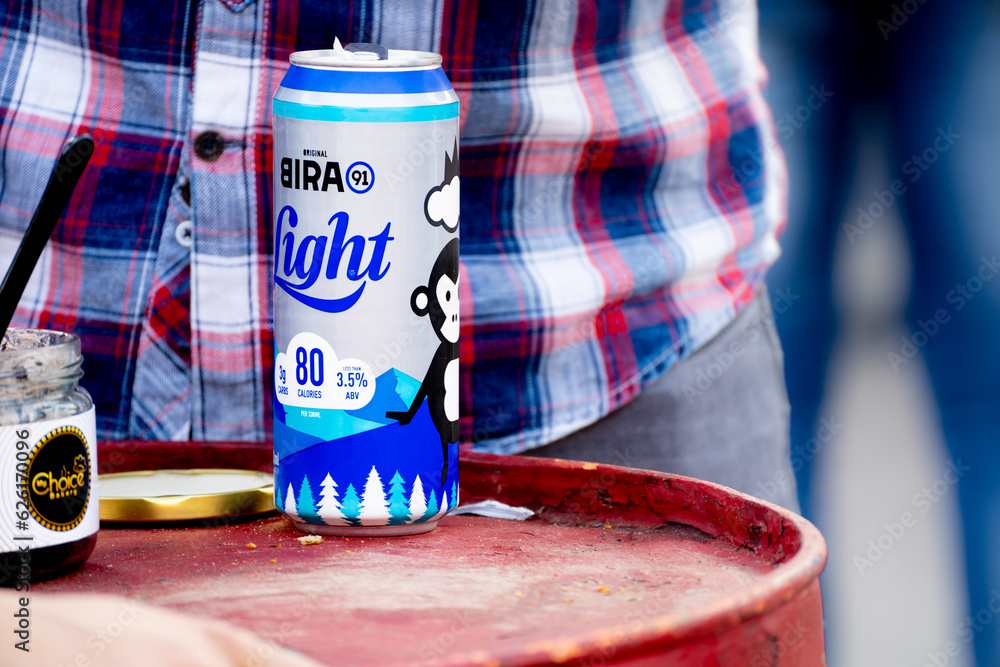 Can of Bira light beer placed on top of a table in an outdoor venue ...
