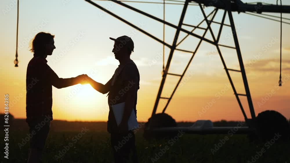 Agriculture.Teamwork of farmers in corn field. Irrigation system.Work ...