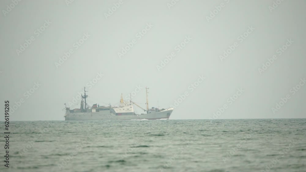 Big fishing boat trawling and catching fish as it crosses the sea at ...