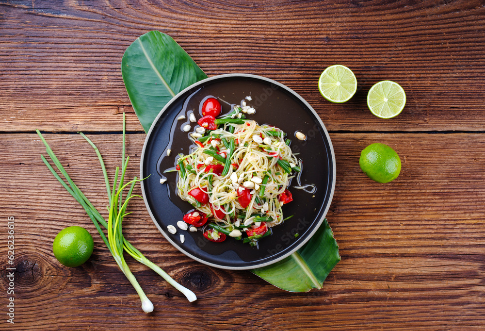 Traditional Thai green papaya som tam salad with green papaya slices ...