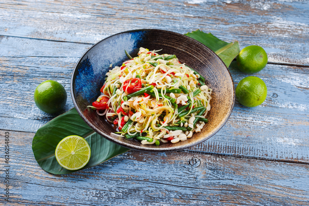 Traditional Thai green papaya som tam salad with green papaya slices ...