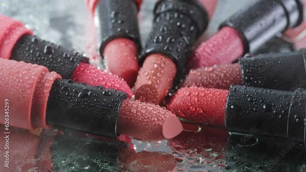 Red lipsticks make up close up background with smoke and water drops ...