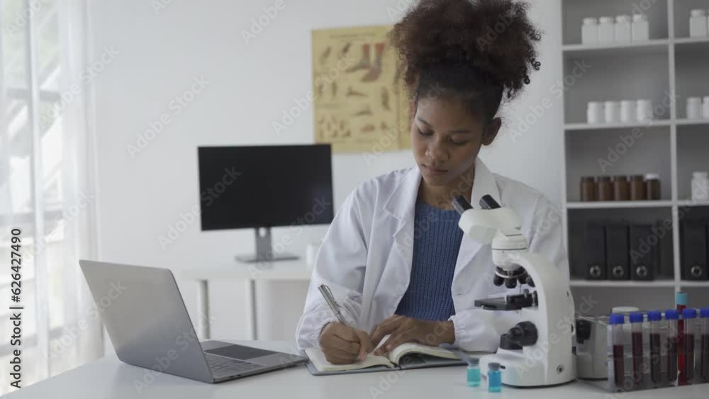 African female scientist in laboratory doing experiment in science lab ...