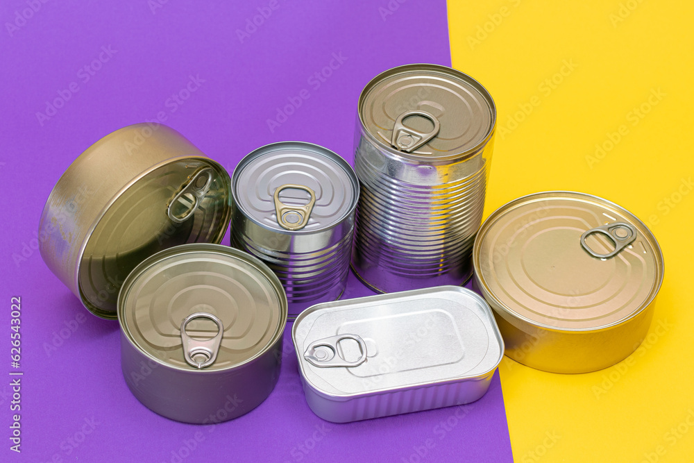 A Group of Stacked Tin Cans with Blank Edges on Split Yellow and Violet ...