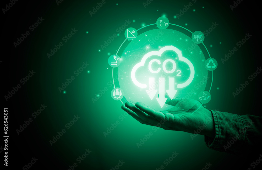 Hand holding CO2 reducing icon with environment symbol for decrease CO2 , carbon footprint and ...