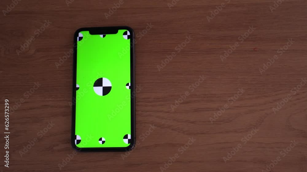Smart phone place on table wood with green screen, Close-up the cell ...