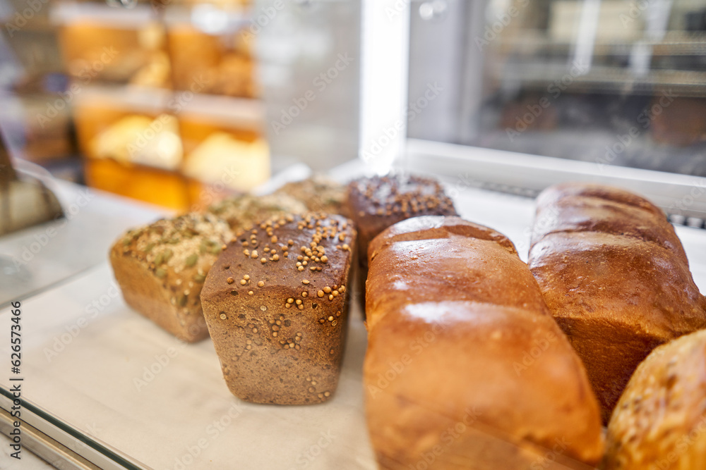 Different kinds of bread on the counter in the bakery shop. Fresh bread ...