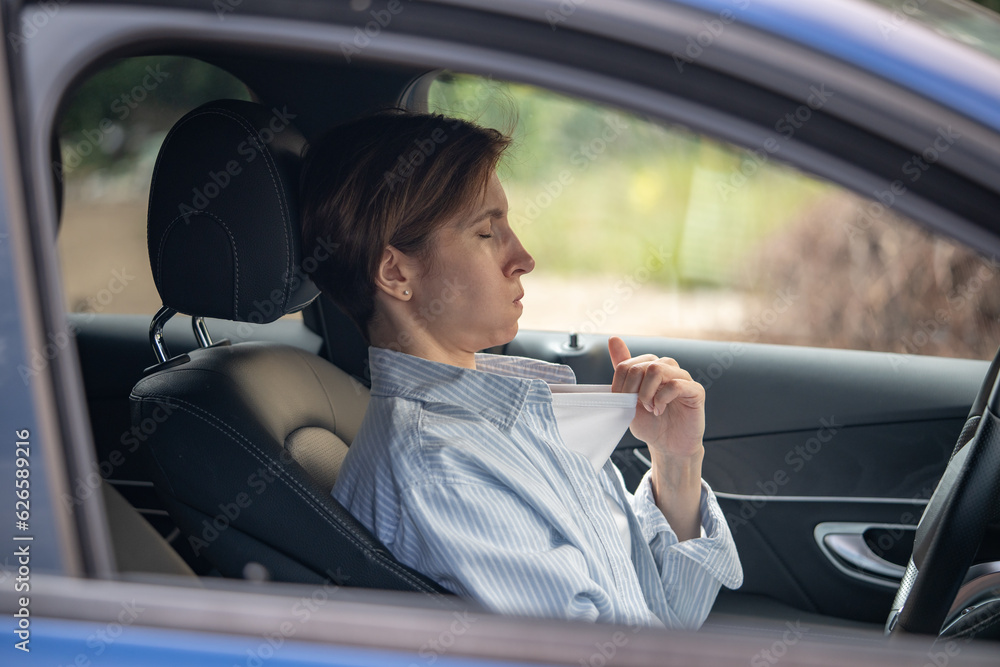 Woman sweating in heat blowing on chest, broken air conditioner in car ...