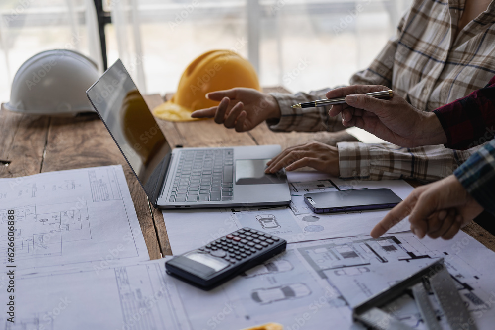 Engineers point to buildings on blueprints and use building design ...