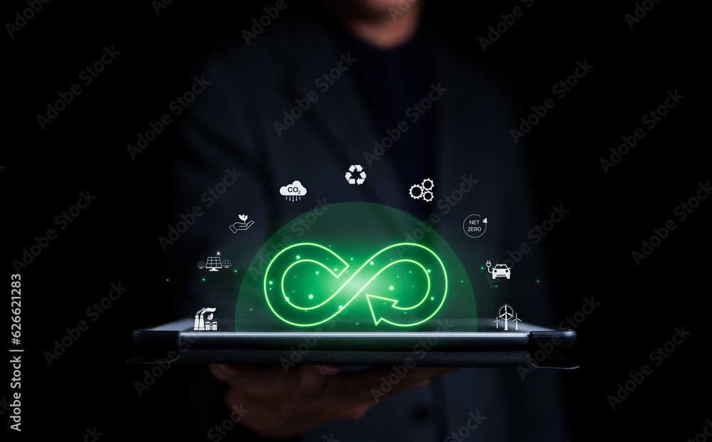 Businessman holding tablet with infinity symbol with circle economic ...