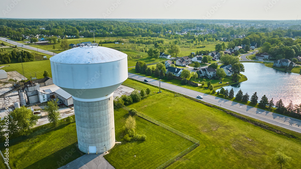 Water tower near processing plant and neighborhood in rural area with ...