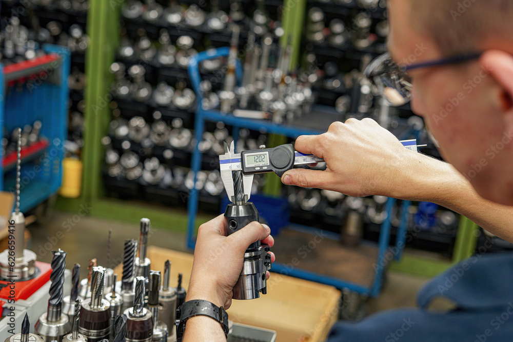 Measuring a cutting tool with a caliper for a CNC machine tool. Stock ...