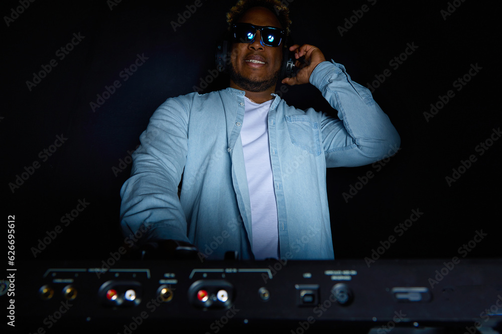 African American nightclub dj posing behind professional dj equipment ...