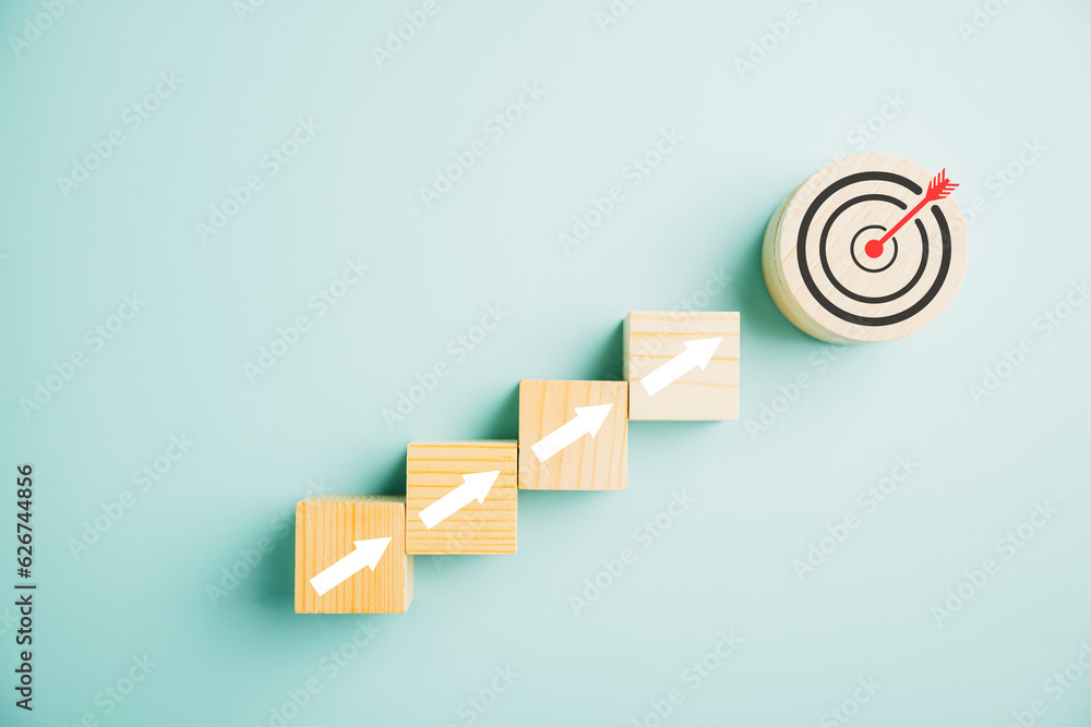 Target icon integrated into wooden blocks with rise up arrows, portraying business growth. Bar ...