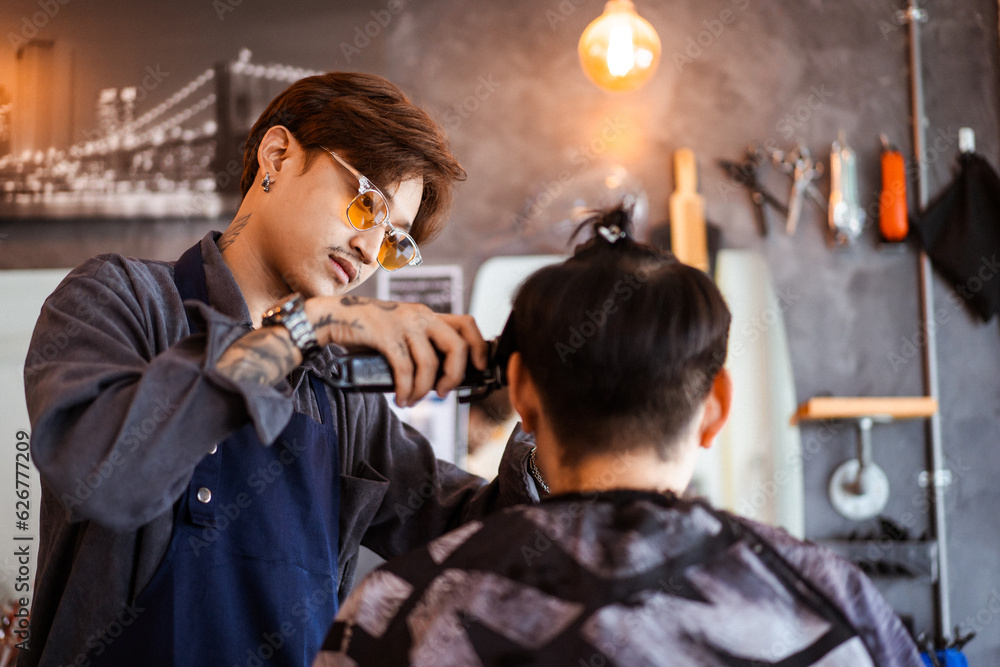 Handsome Asian man having a haircut at street hairdresser shop ...