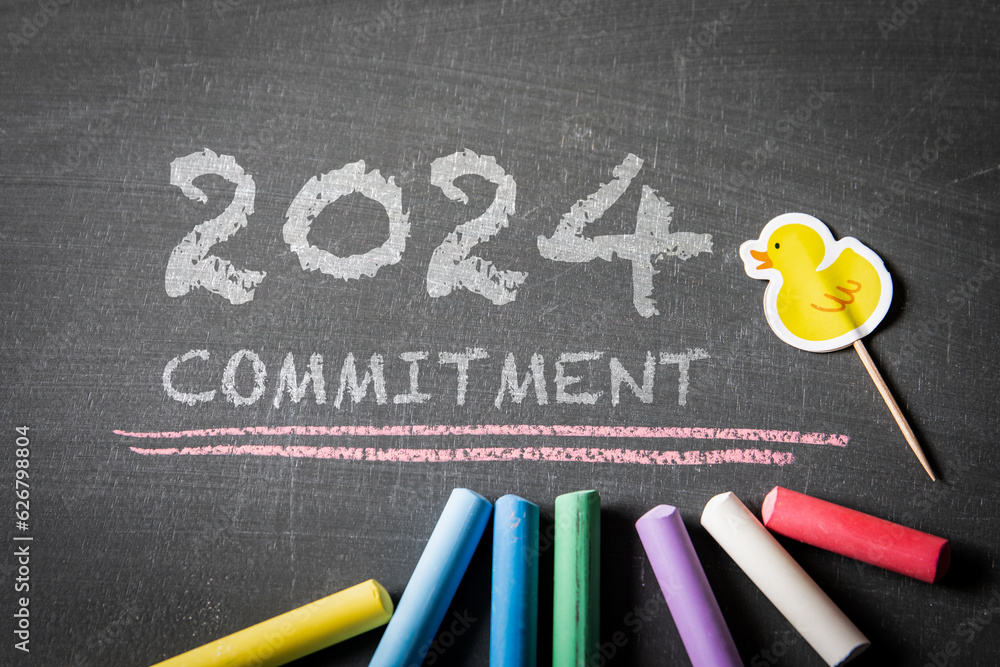 2024 Commitment Concept. Colored pieces of chalk on a dark chalkboard ...