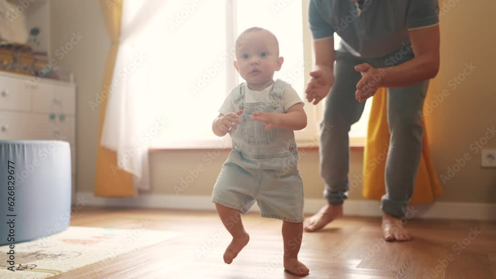 baby first steps. baby goes to her father at window learns to walk to ...