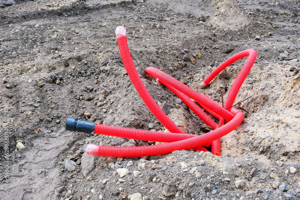 Corrugated red pipes for cable lines sticking out of the ground Stock ...