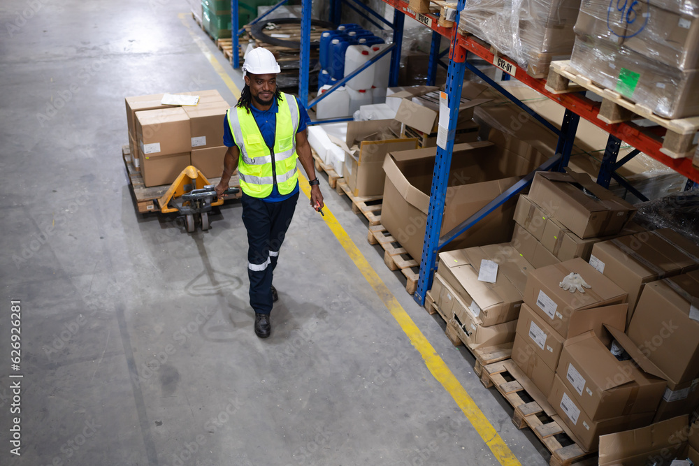Young man pulling hand pallet truck loading package boxes stacked in ...