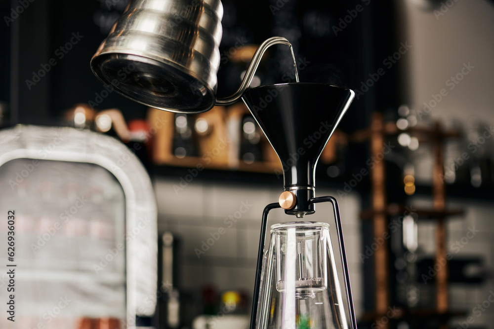 Foto de boiling water pouring from drip kettle into siphon coffee maker ...