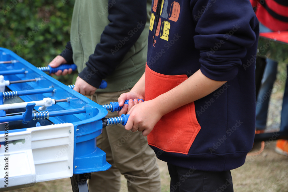 Children playing metegol. Foosball. Soccer hall game. Traditional game ...
