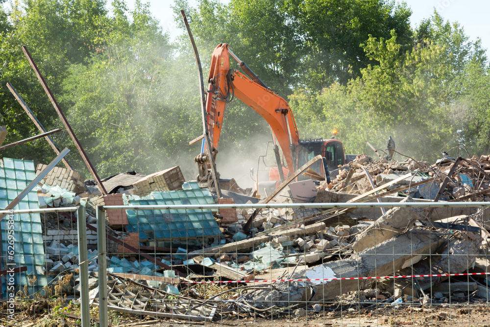An excavator destroys building of an old emergency cinema. Destruction ...